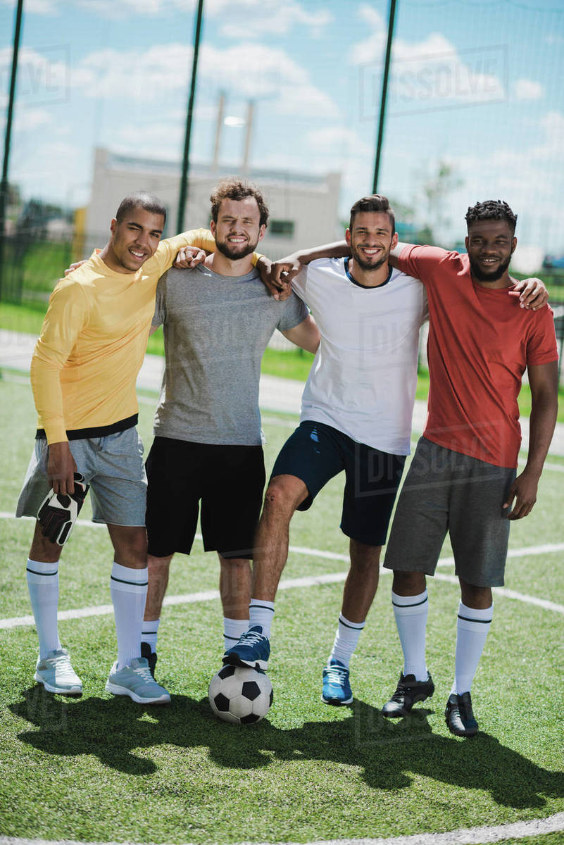 Multiethnic soccer team standing on soccer pitch after game - Royalty ...