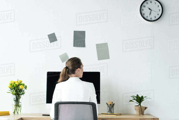 Back view of businesswoman at workplace with computer screen in office ...