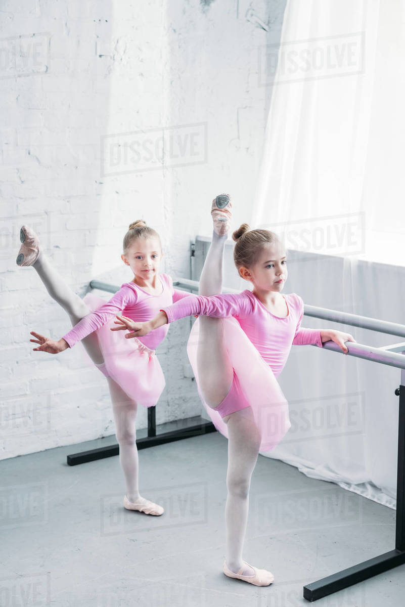 Cute little kids in pink tutu skirts stretching and dancing in ballet ...