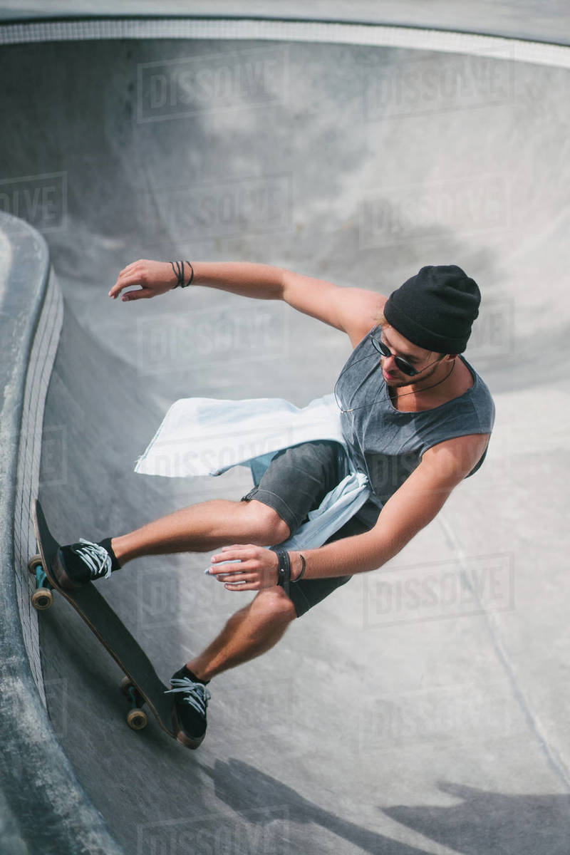 High angle view of young skater skating on longboard at skatepark ...