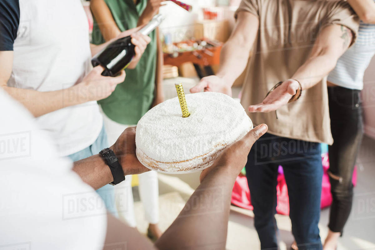 Cropped view of people celebrating birthday with cake at party ...