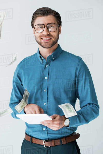 Money falling around young man with tablet isolated on white - Royalty ...
