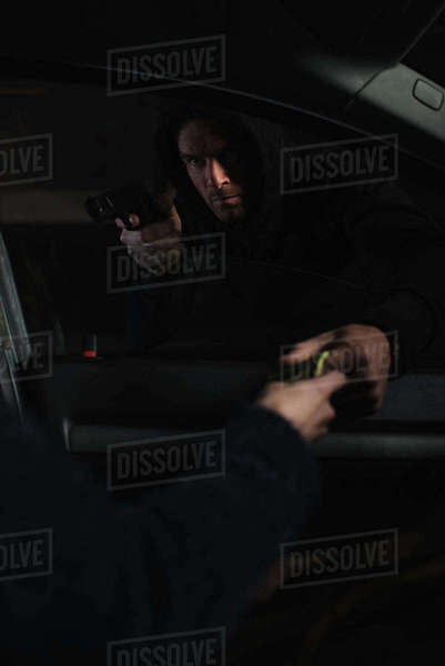 Male mugger aiming by gun on woman while she giving him cash money ...