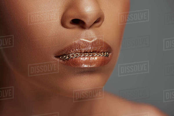 cropped shot of african american woman with chain on lips isolated on ...
