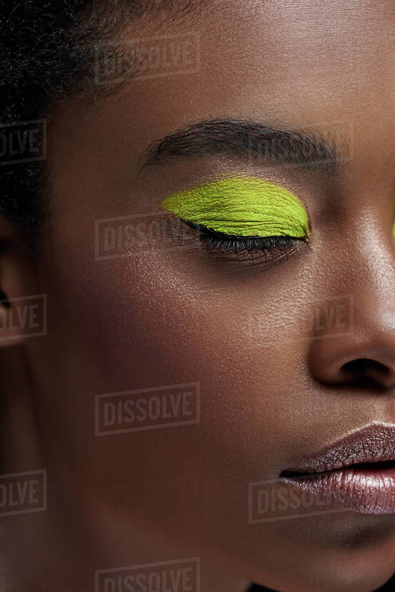 partial view of african american model with bright neon eye shadow ...