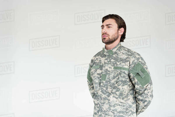 side view of confident bearded soldier in military uniform looking away ...
