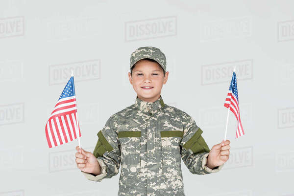 portrait of smiling child in military uniform with american flagpoles ...