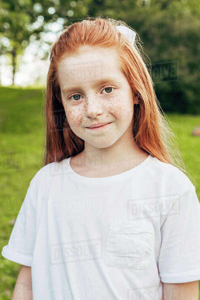 portrait of adorable red haired child smiling at camera in park - Stock ...