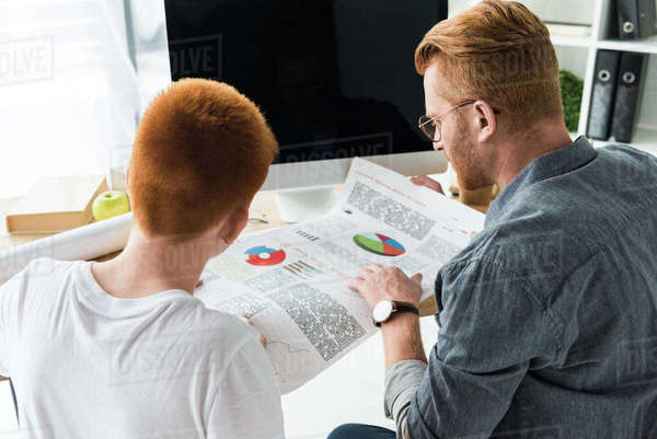 back view of father and son looking at diagram at home - Royalty-free ...
