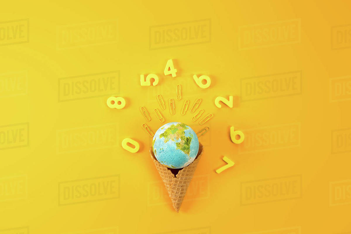 top view of earth globe in waffle cone surrounded with digits on yellow ...