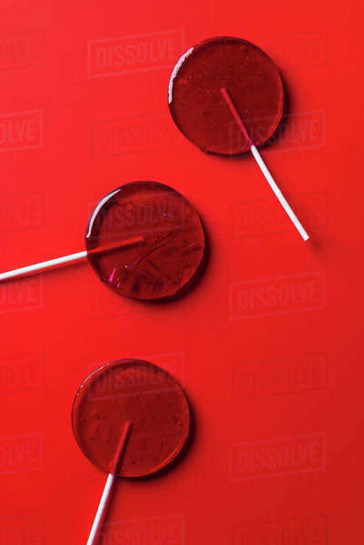 top view of three lollipops on red surface - Royalty-free Stock Photo ...