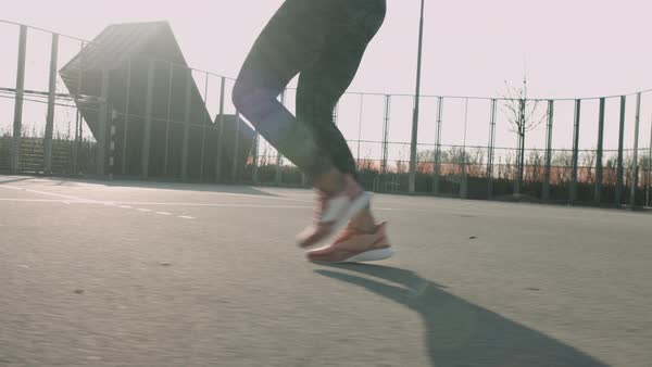 Energetic athletic woman doing intense running exercises on a fenced ...