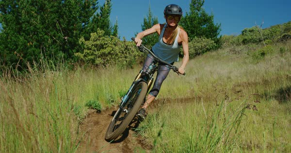 Woman riding her mountain bike around a berm turn in slow motion - 4K ...