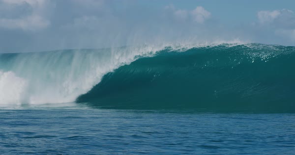 Powerful ocean wave breaking and barreling with spray in slow motion ...