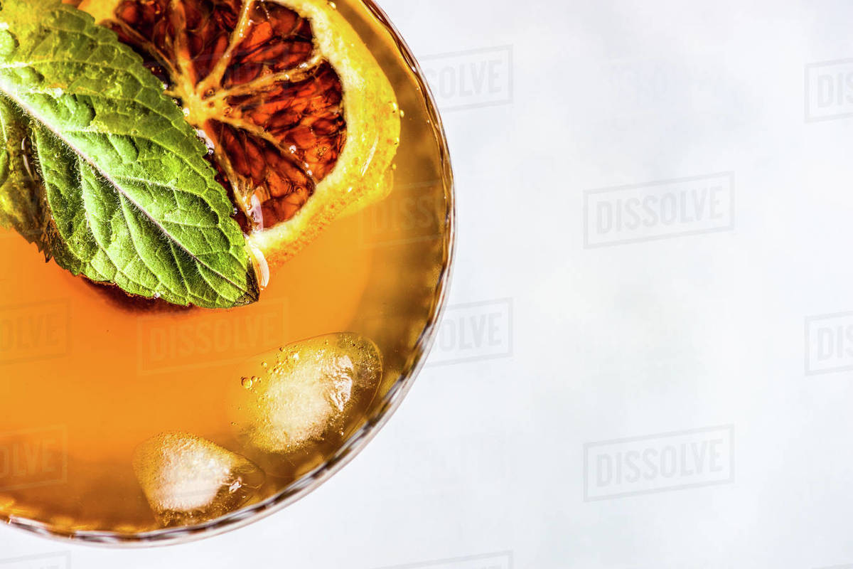 Overhead view of a cocktail with a slice of orange and fresh mint ...