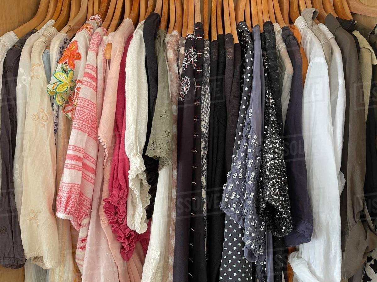 Close-up of assorted clothes hanging in a wardrobe - Stock Photo - Dissolve