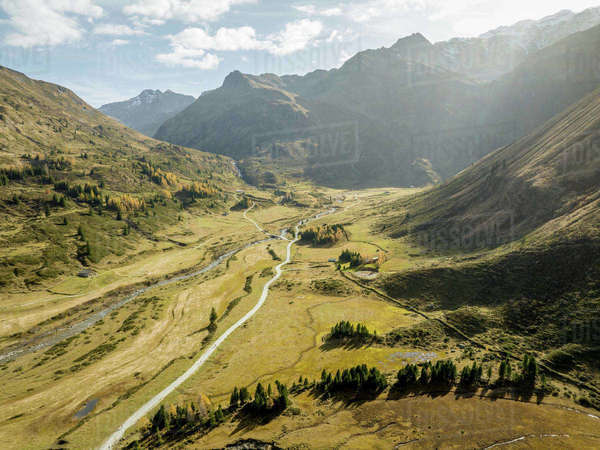 Aerial view of river and road through alpine highlands in autumn ...