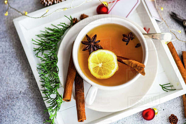 Overhead view of a cup of Christmas lemon and spice tea with Christmas ...
