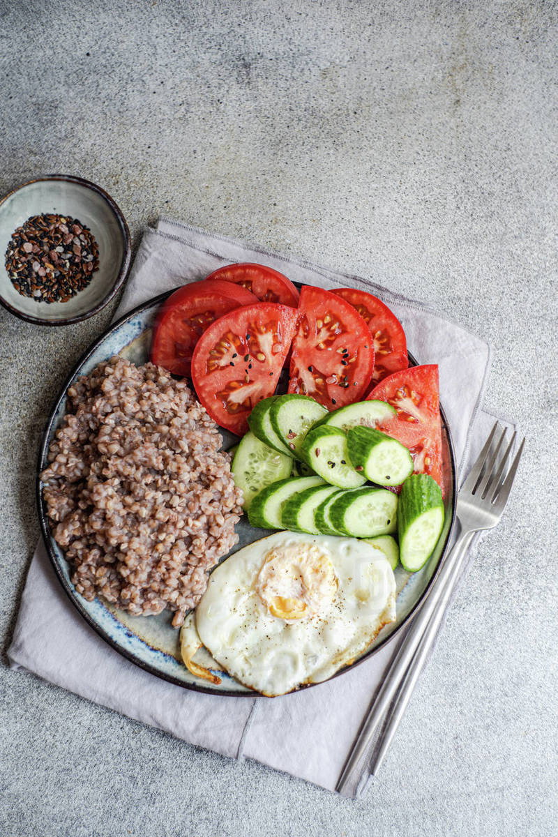 Overhead view of a healthy lunch plate with buckwheat, cucumber, tomato ...