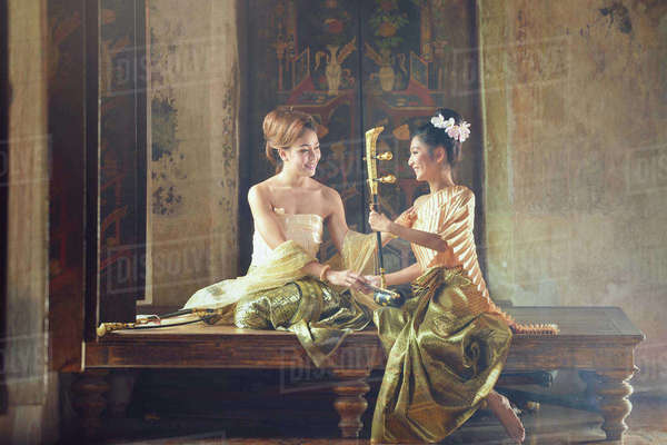 Two Asian women in traditional Thai clothing with a Thai Saw Duang ...