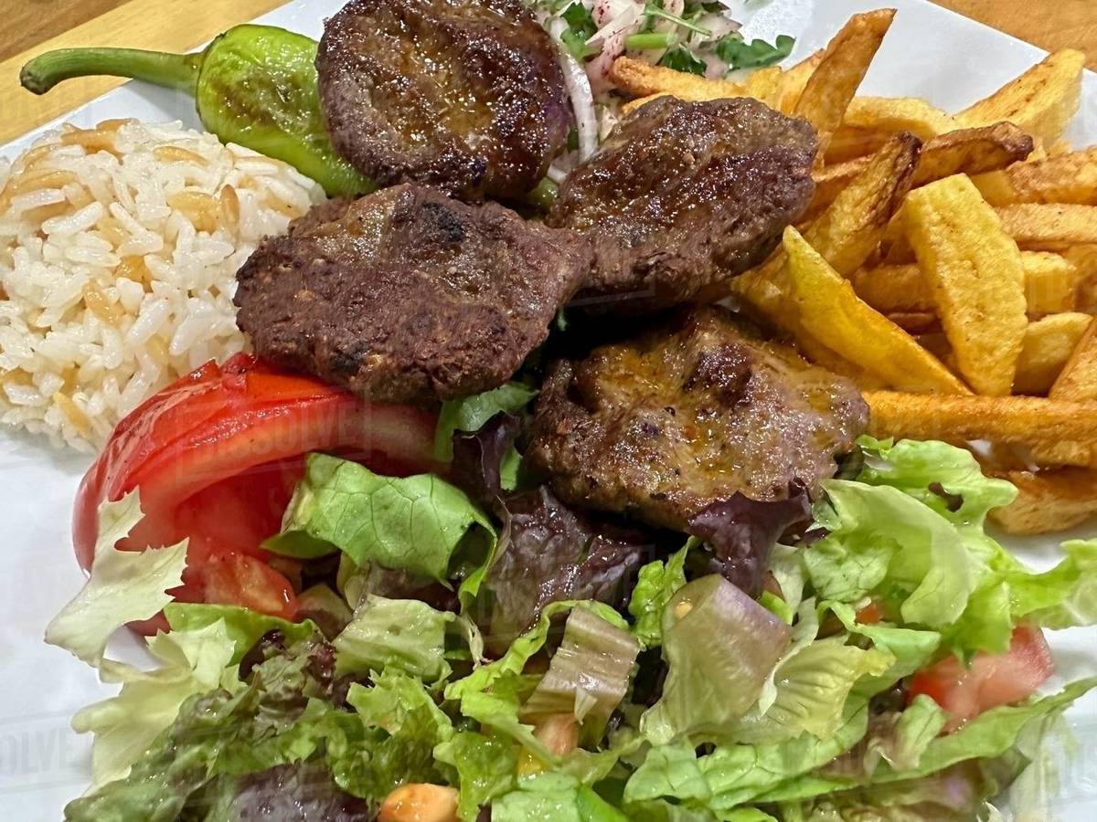 Close-up of Turkish kofta meatballs with chips, rice and salad - Stock ...