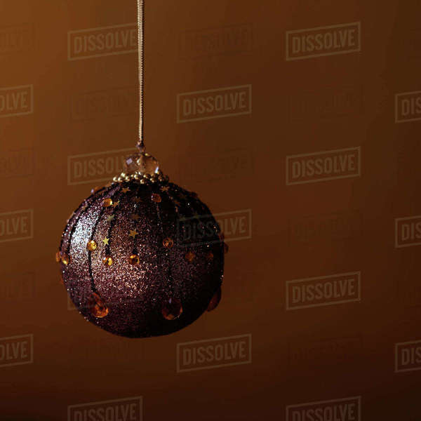 Christmas bauble hanging on string - Stock Photo - Dissolve