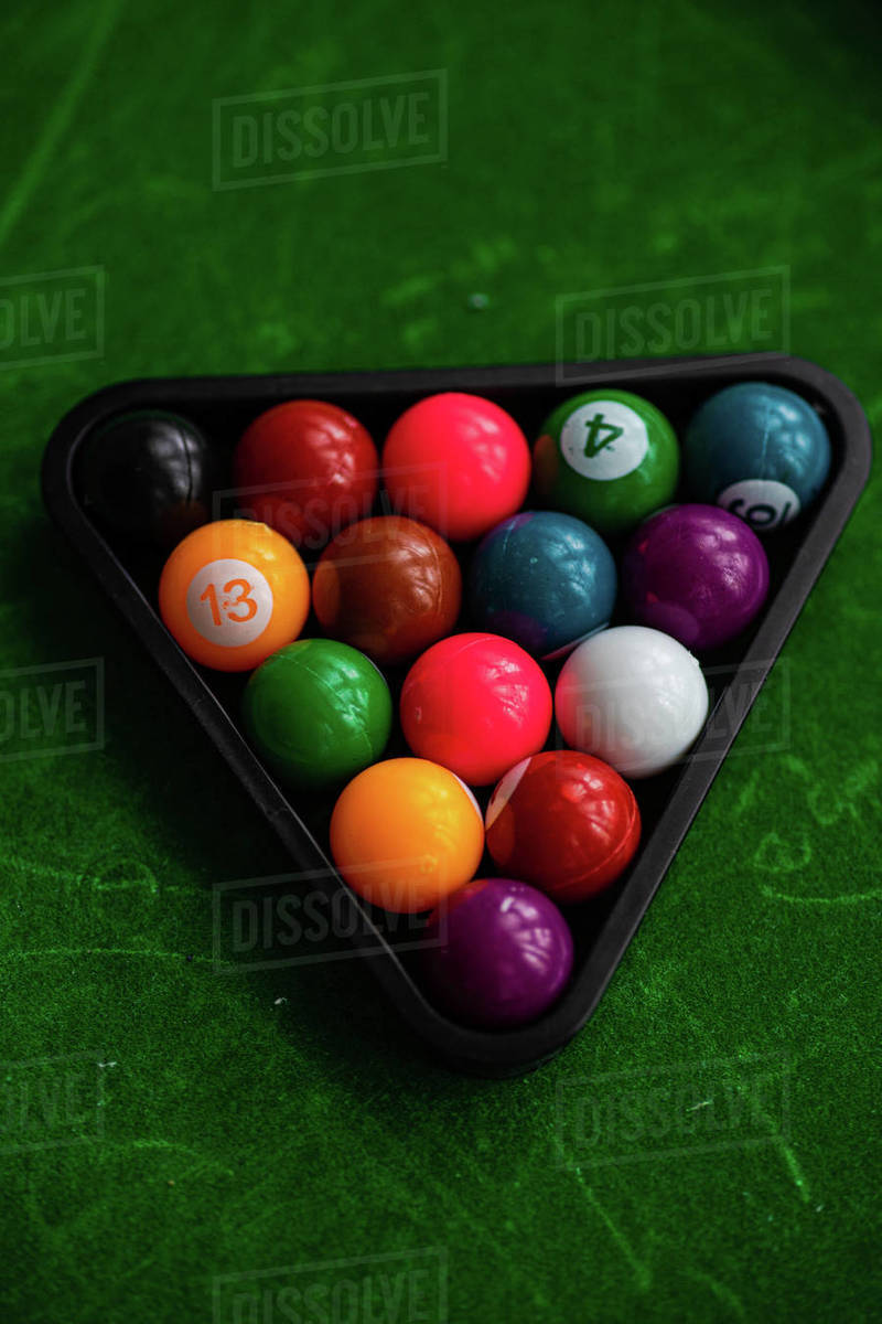 Overhead view of snooker balls in a triangle snooker frame on a green ...