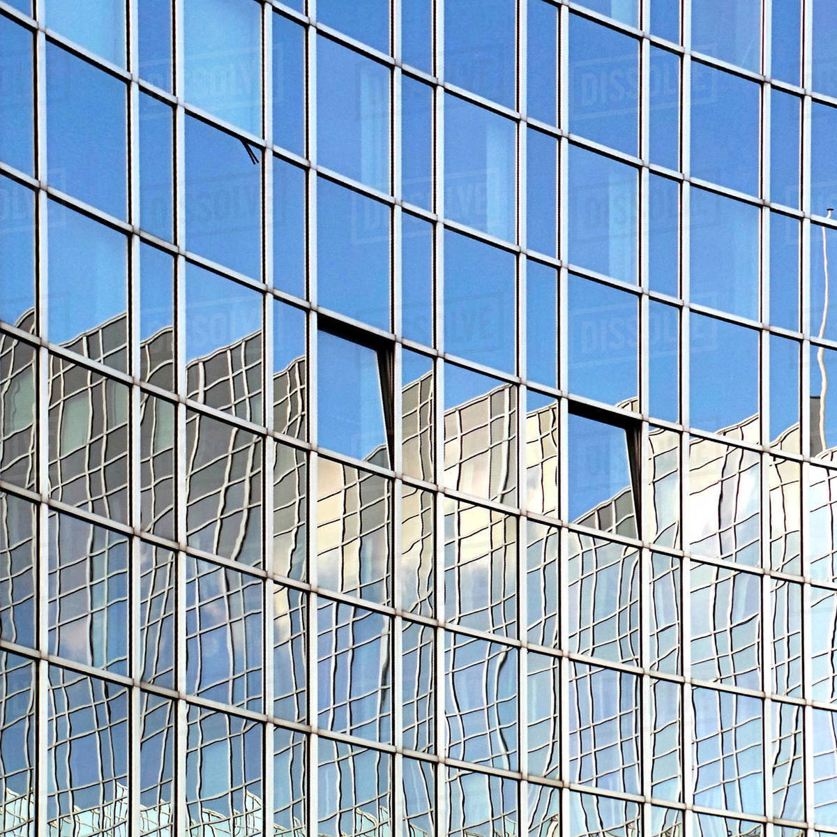 Reflecting in glass facade with two open windows - Stock Photo - Dissolve