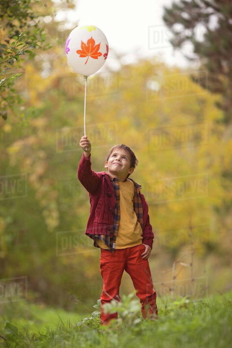 Boy holding a balloon - Royalty-free Stock Photo | Dissolve