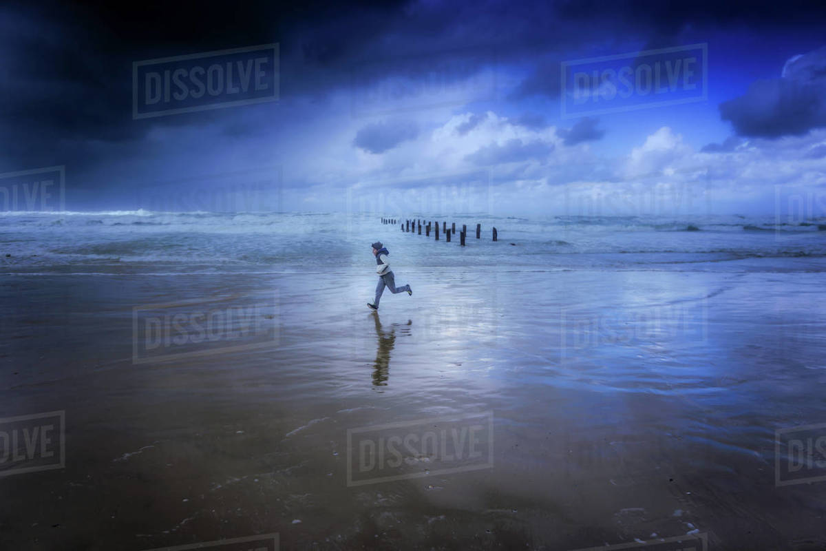 Boy running along beach in a storm, Tel Aviv, Israel - Royalty-free ...