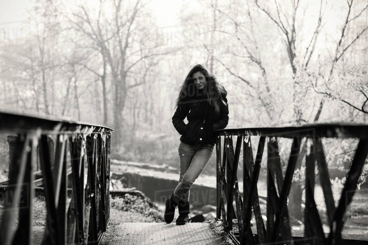 Woman standing on a bridge in winter - Stock Photo - Dissolve