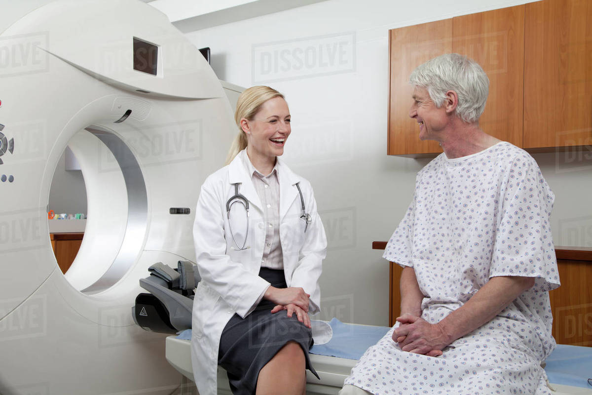Doctor talking to male patient in hospital scanning room - Royalty-free ...