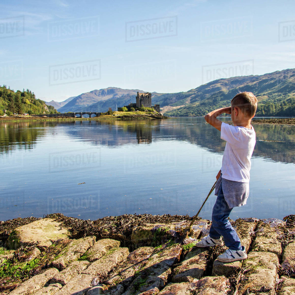 UK, Scotland, Boy (6-7) looking at Eileen Donan Castle - Stock Photo ...