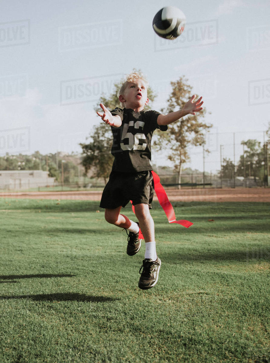 Boy playing flag football, catching a ball, California, United States ...