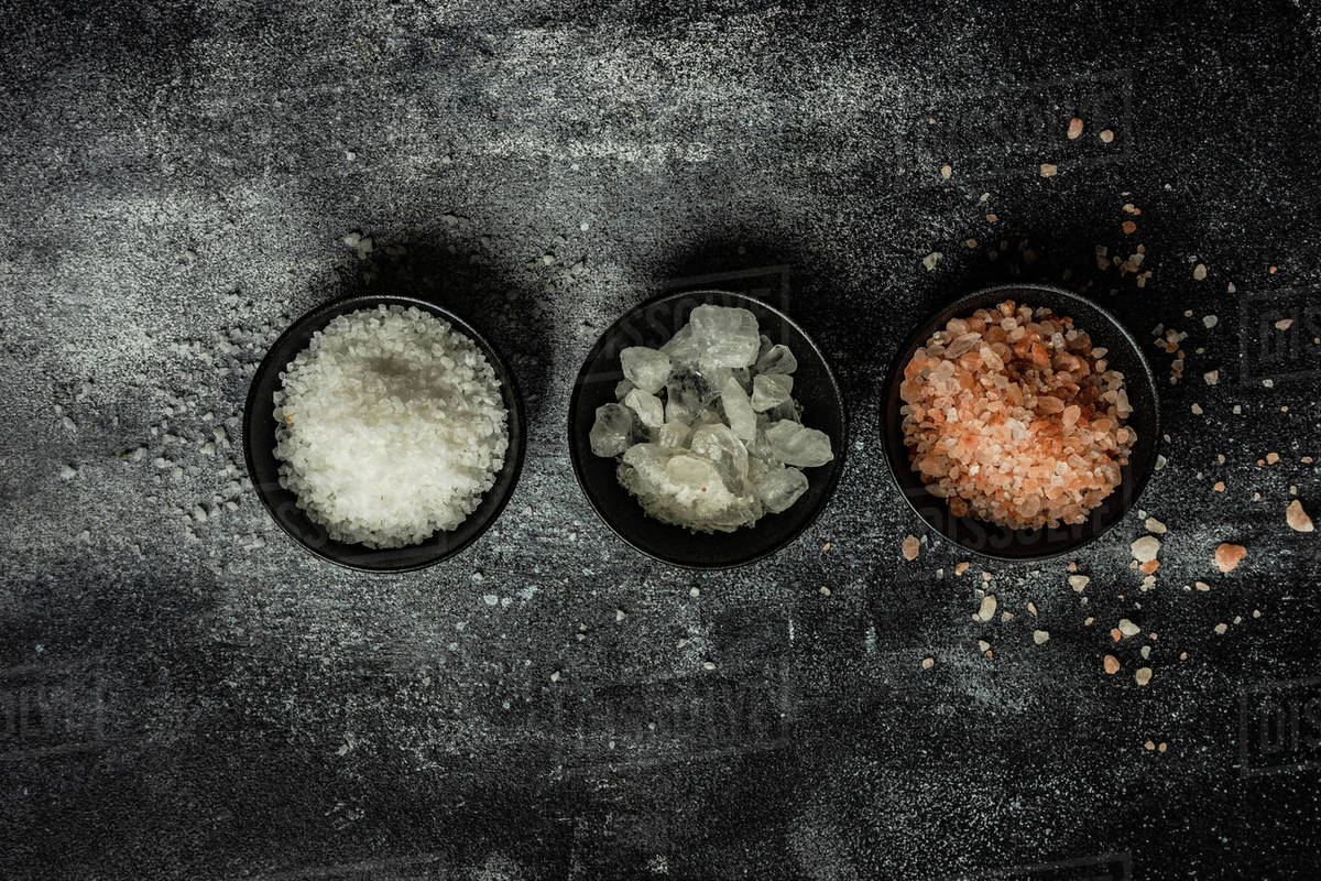 Overhead view of three bowls of assorted rock salt on a table - Royalty ...