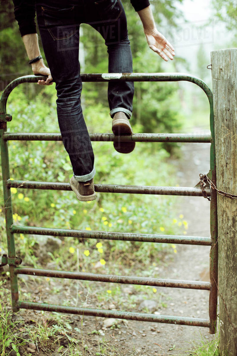 Man climbing over barrier - Royalty-free Stock Photo | Dissolve