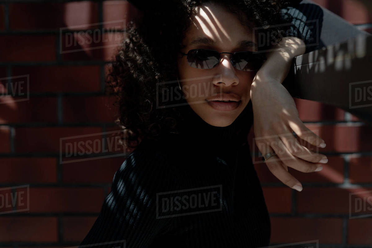 Portrait of a beautiful teenage girl standing in shadows - Royalty-free ...