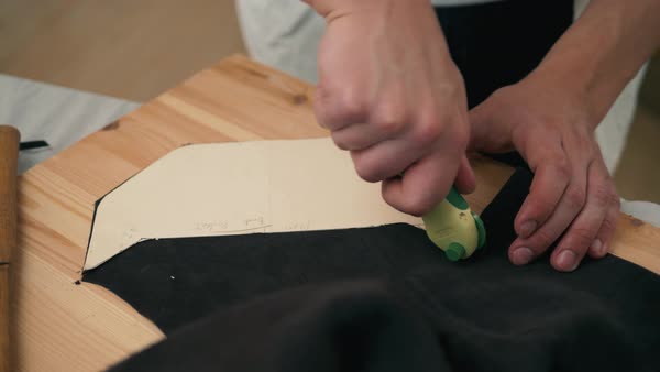 Man cut natural leather with knife, craftsman close up macro produce ...