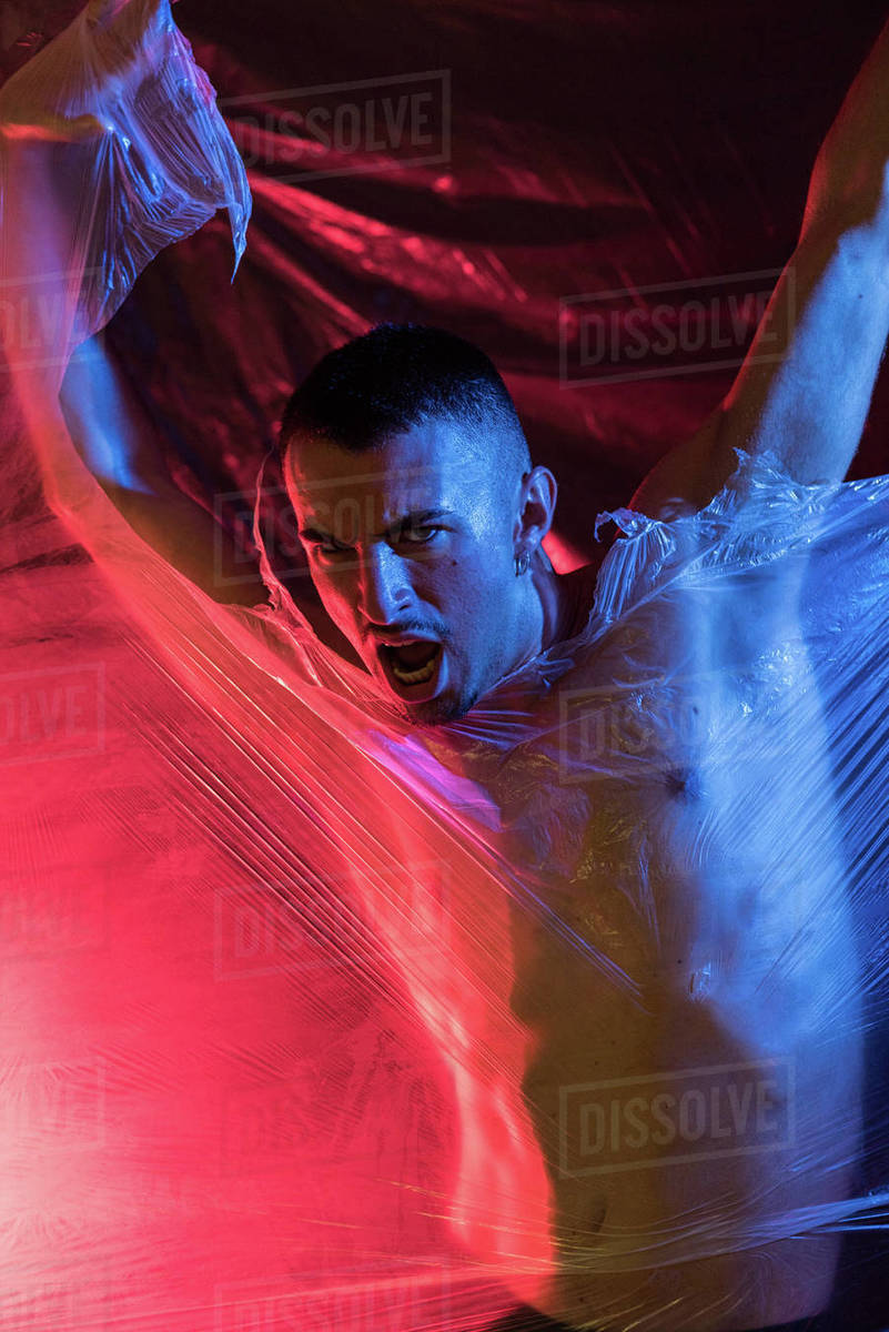 Aggressive male in casual clothing shouting and looking at camera while ...