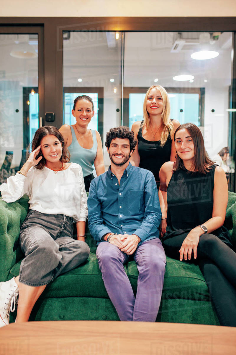Group of optimistic young coworkers in casual outfits gathering ...