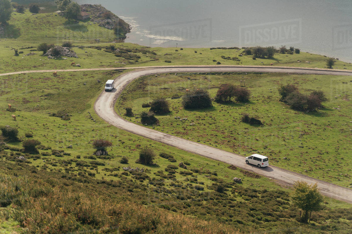 From above picturesque scenery of cars driving along narrow rural road ...