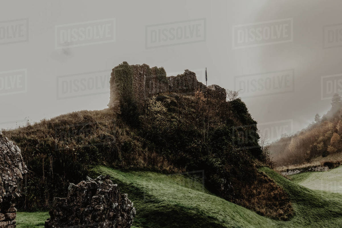 Destroyed old stone castle with fog with walls and stairs with tower on ...