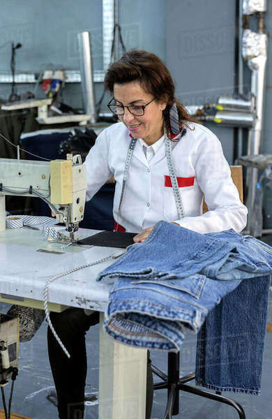 Working woman hands in textile factory sewing on industrial sewing ...