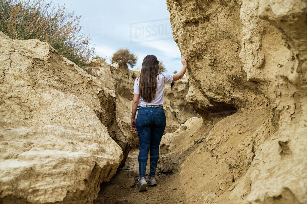 Back view of faceless woman traveler in casual clothing in narrow ...