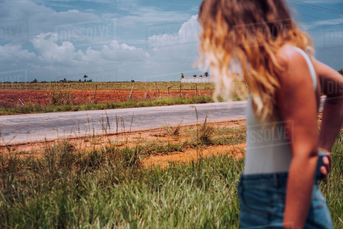 Side view of female traveler in casual wear standing on crossroad with ...