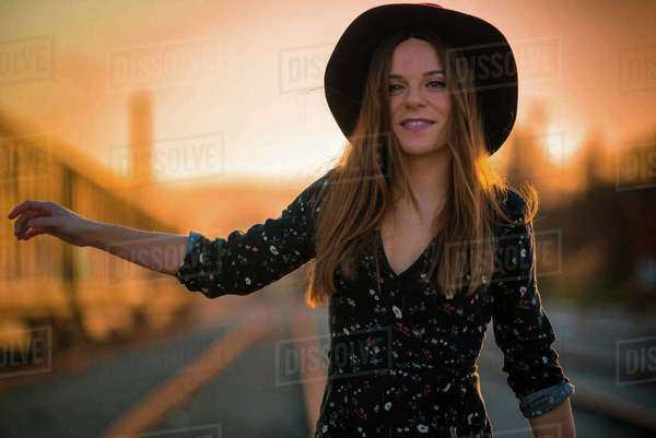 Happy female in stylish hat smiling and trying to catch vehicle while ...