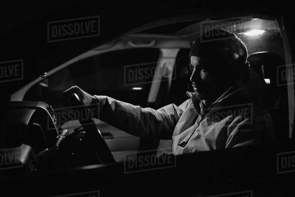Focused man driving car at night time - Stock Photo - Dissolve