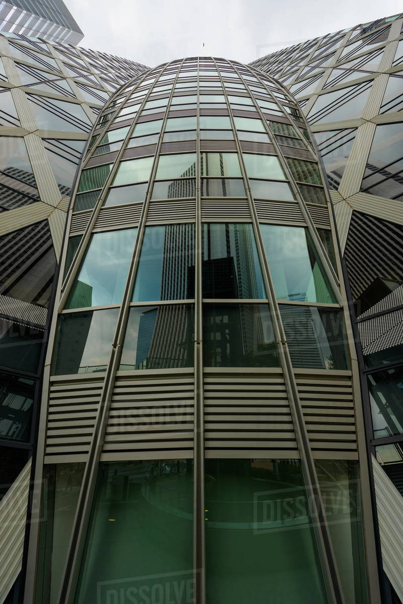 Modern glass tower under cloudy sky - Stock Photo - Dissolve