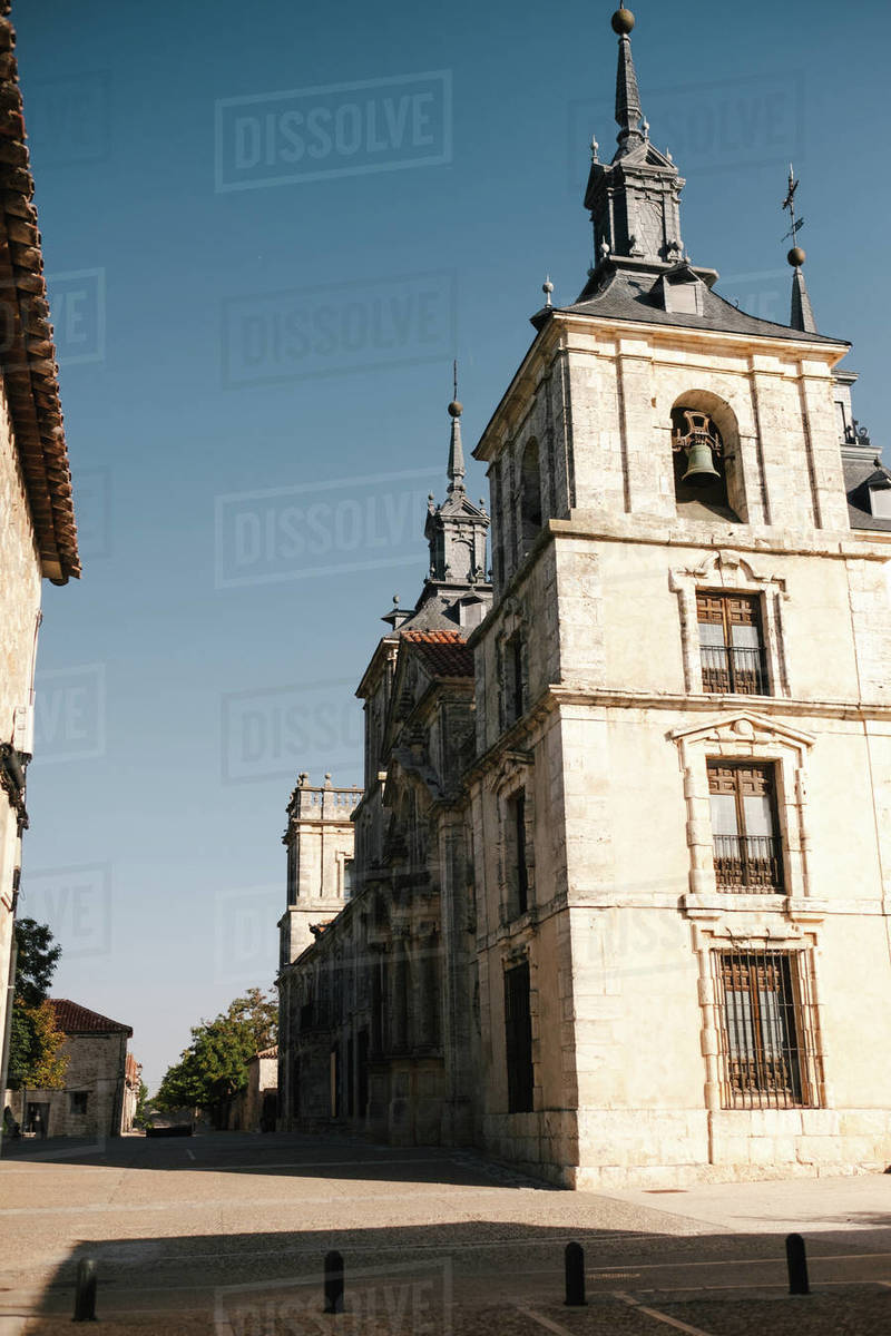 Low angle exterior of aged stone monastery building with bell tower ...