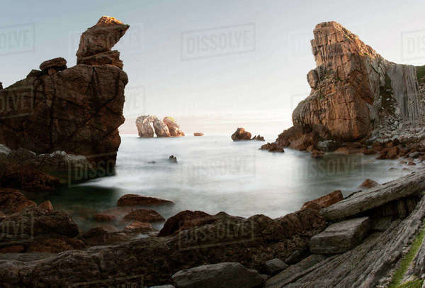 Rough rocky cliff on seashore - Stock Photo - Dissolve